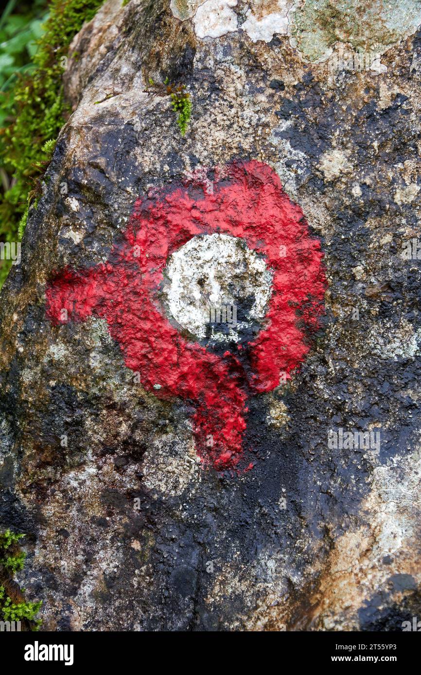 Closeup view of red hiking trail marker on the stone surface. Walking ...
