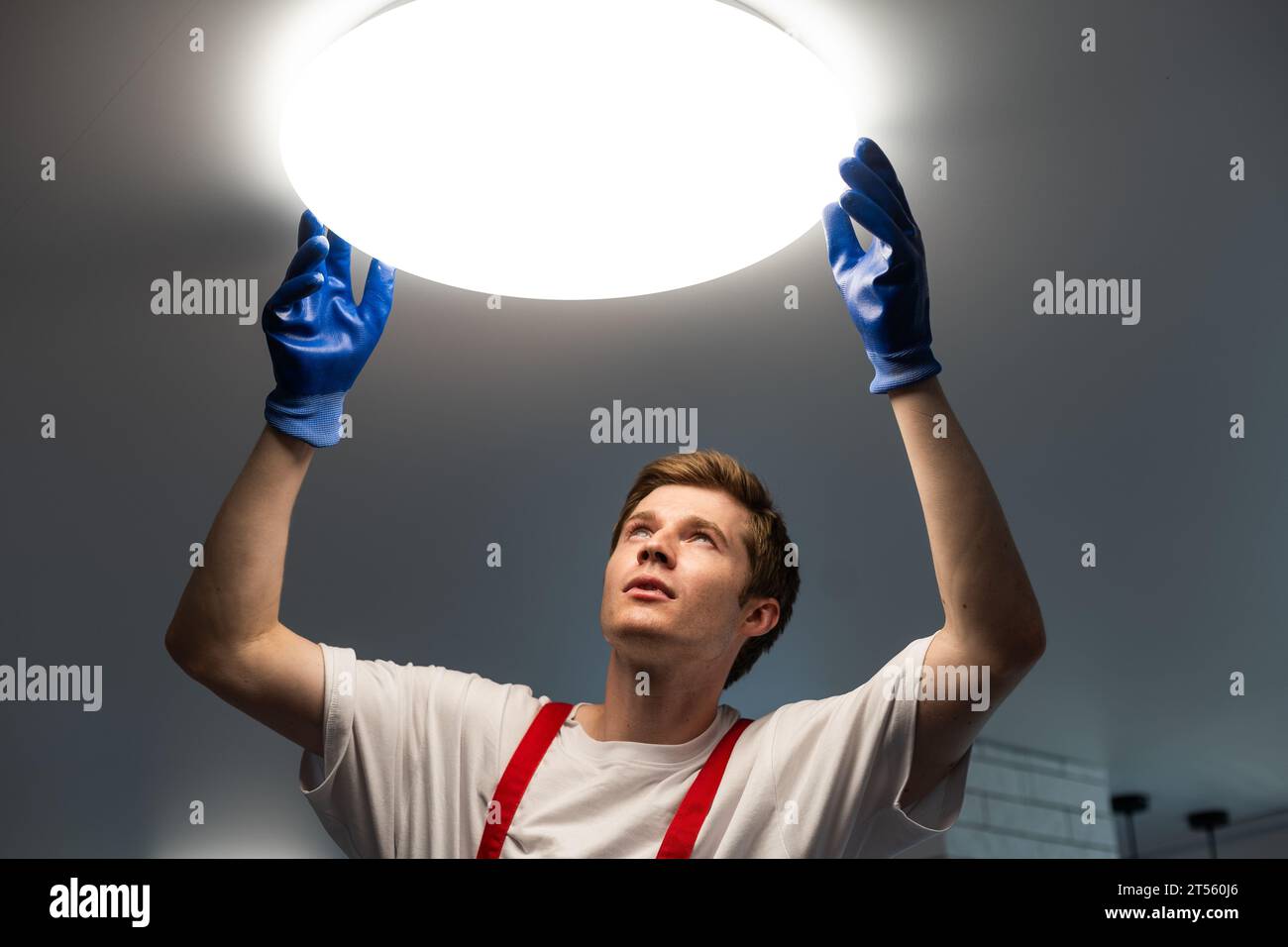 An electrician is installing LED spotlights on the ceiling Stock Photo ...