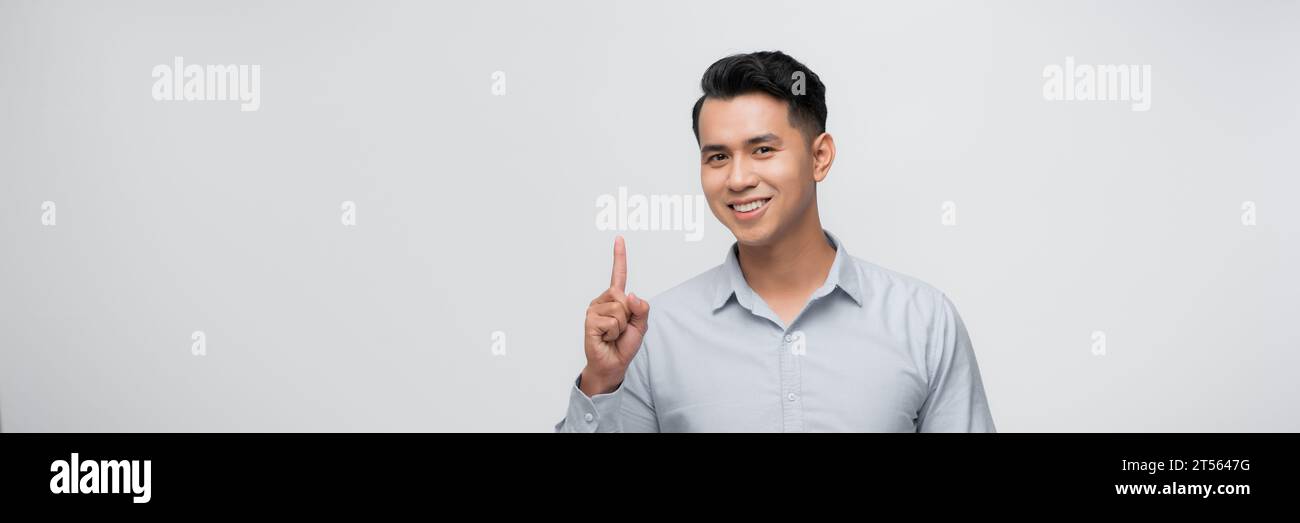 Young handsome man pointing finger up with successful idea. exited and ...
