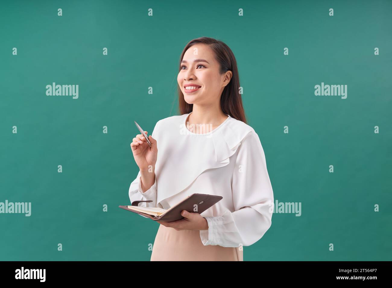 Young business woman standing enjoy using a pen writing diary note book ...