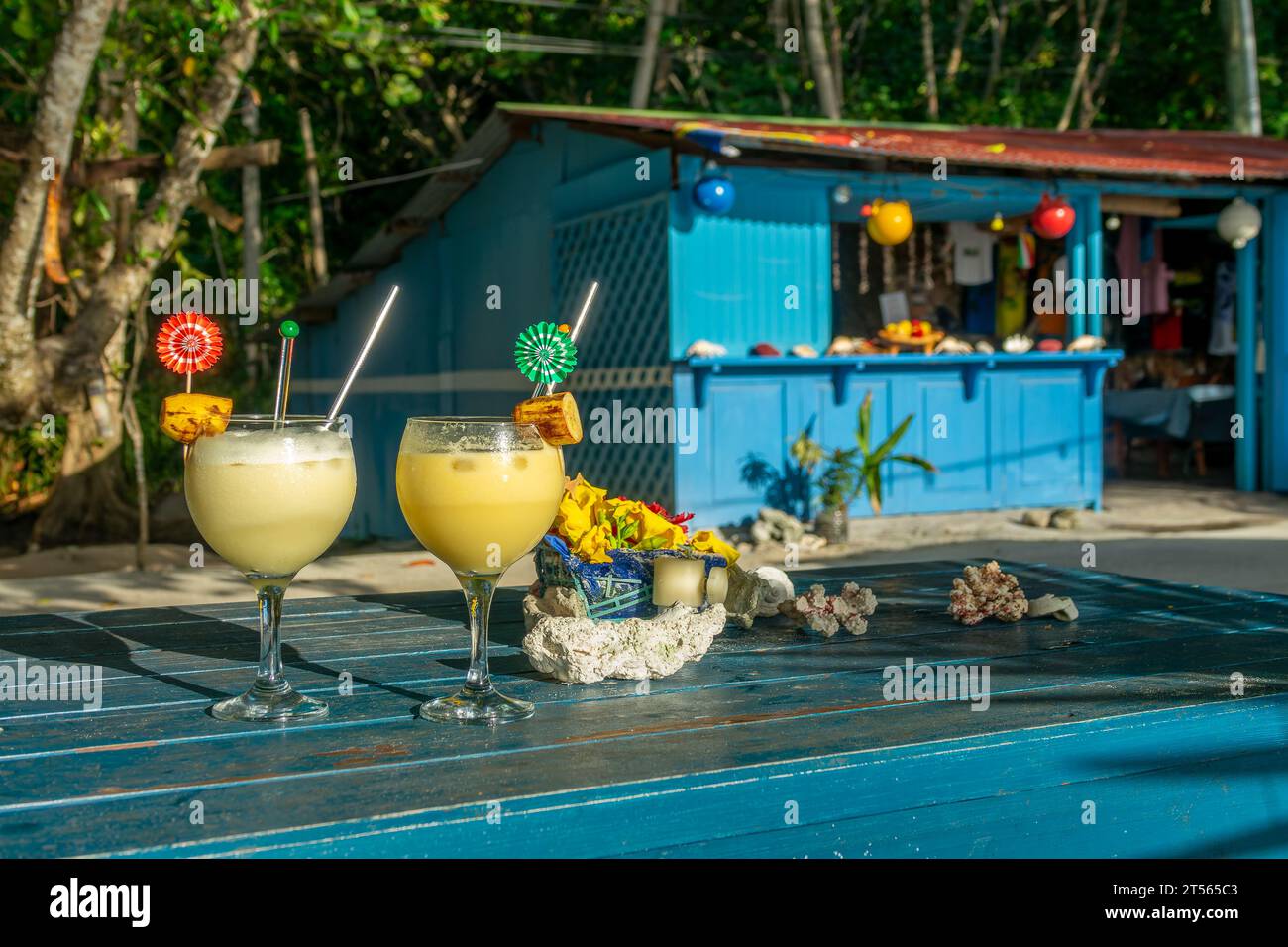 Cocktails on a table in a colorful beach bar in La Digue island ...