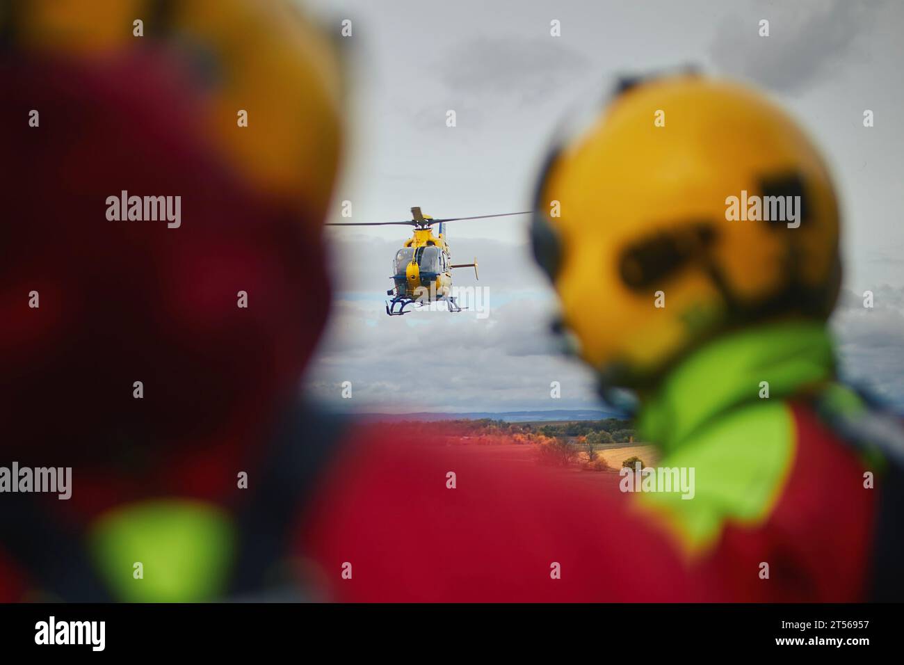 Rear view of paramedics wearing helmets as they looking at the ...