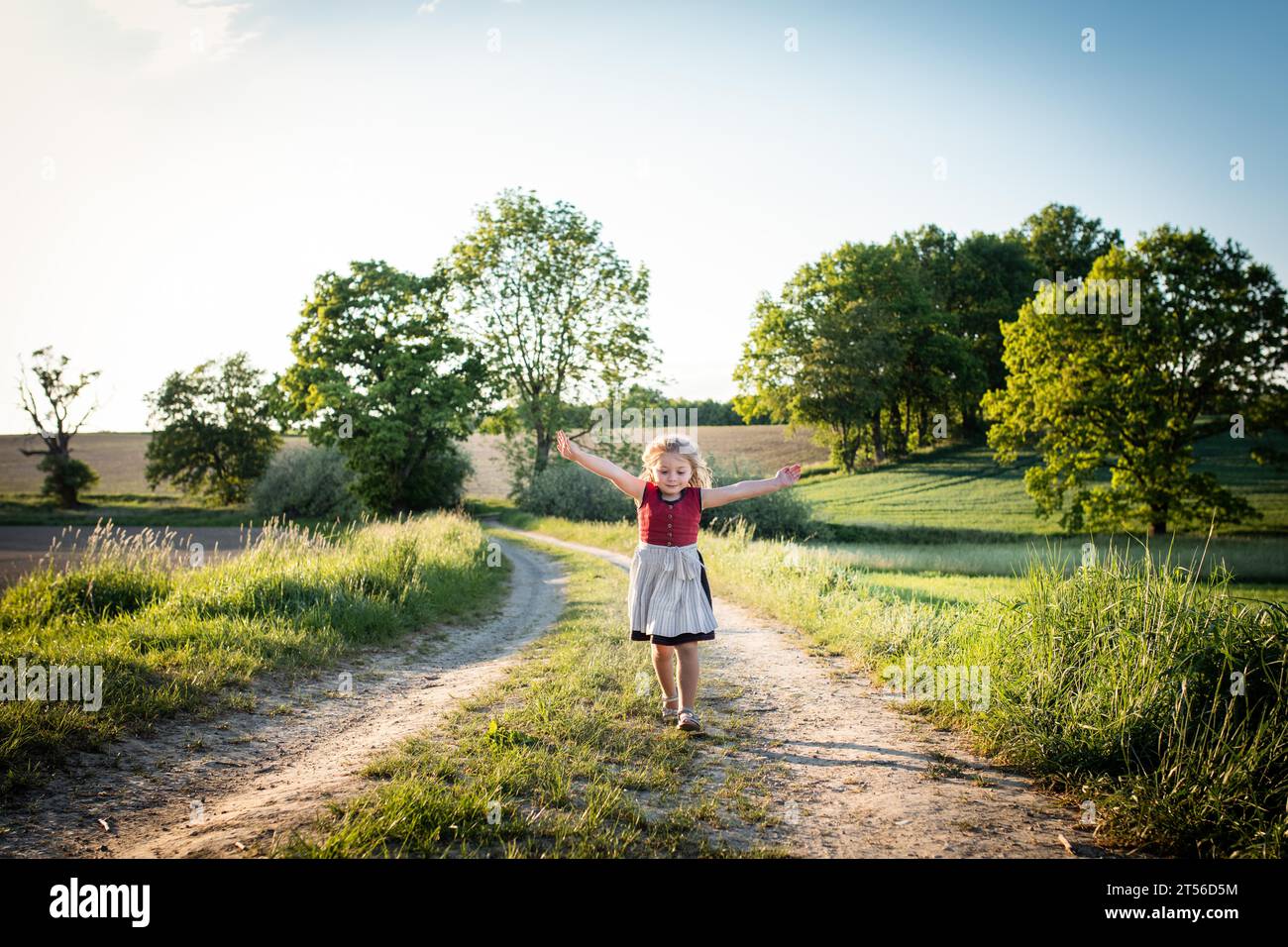 Child singing while walking along a country lane, Altomuenster, Upper ...