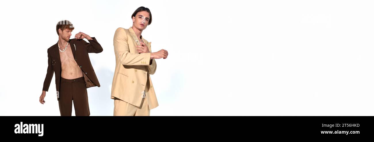 appealing young man in beige suit posing with other male model in ...