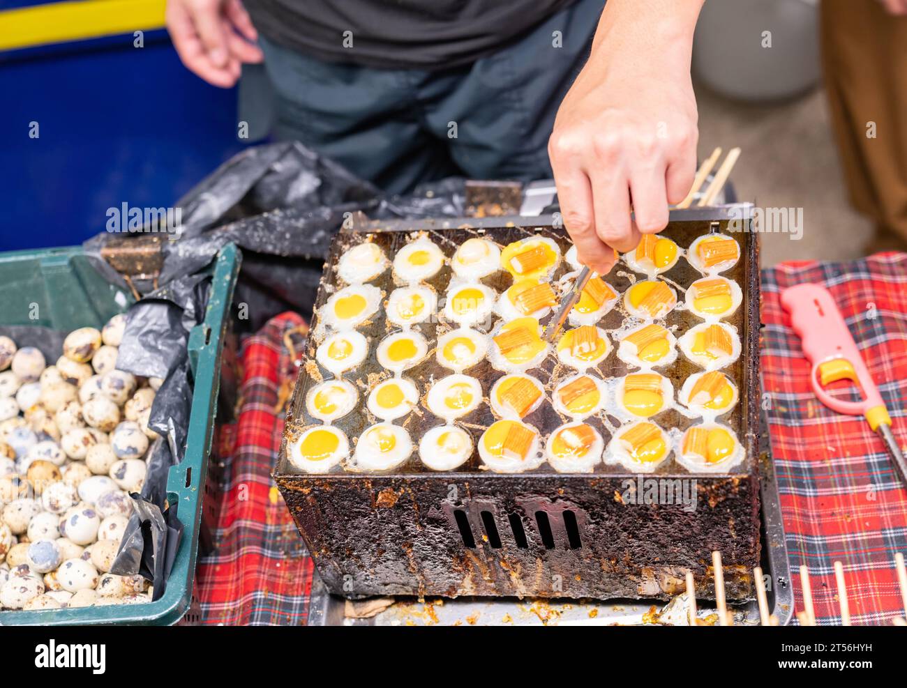Fried quail eggs with crab sticks fried in a pitted pan Stock Photo - Alamy
