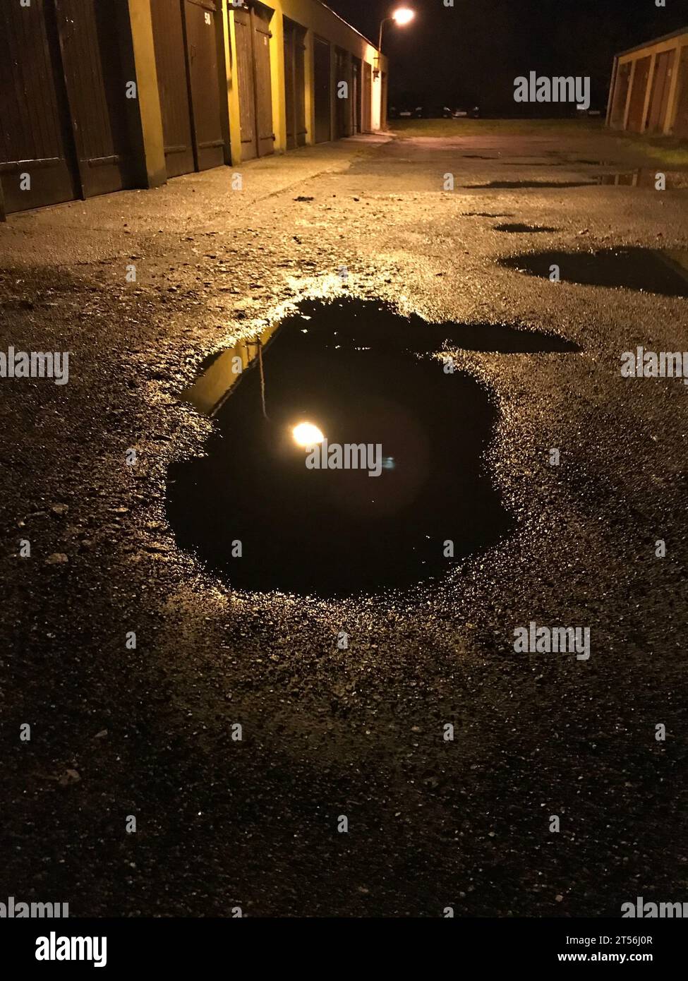 The moon reflecting at night in a puddle on the road Stock Photo - Alamy