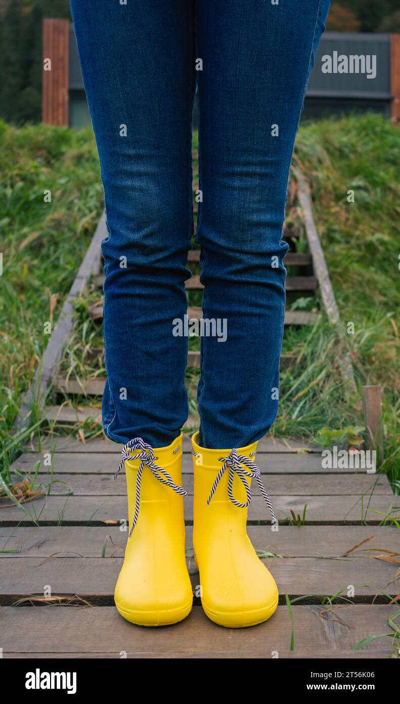 Yellow rubber boots on wet grass background. Walking in the rain ...