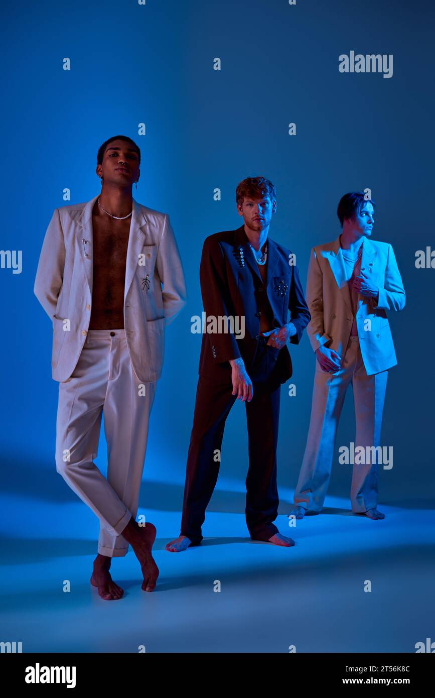 vertical shot of elegant men in classy suits standing and posing with ...