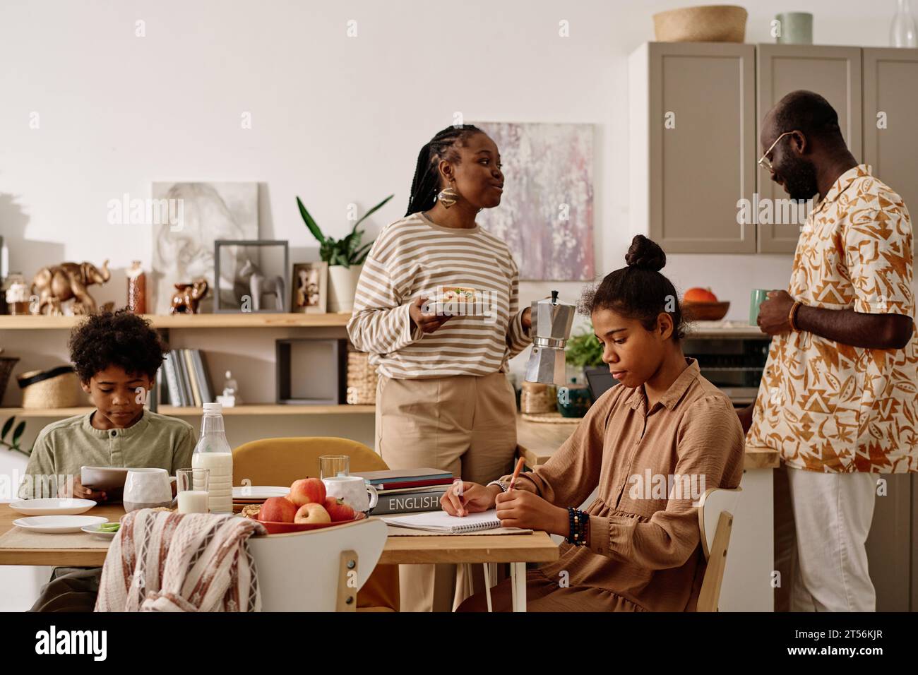 Kids preparing for school when parents having breakfast Stock Photo - Alamy