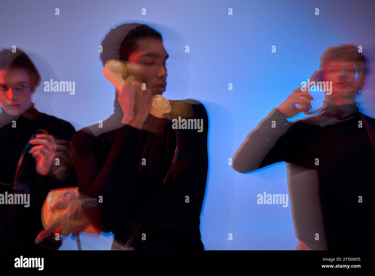 three good looking young multicultural men with landline phones posing ...