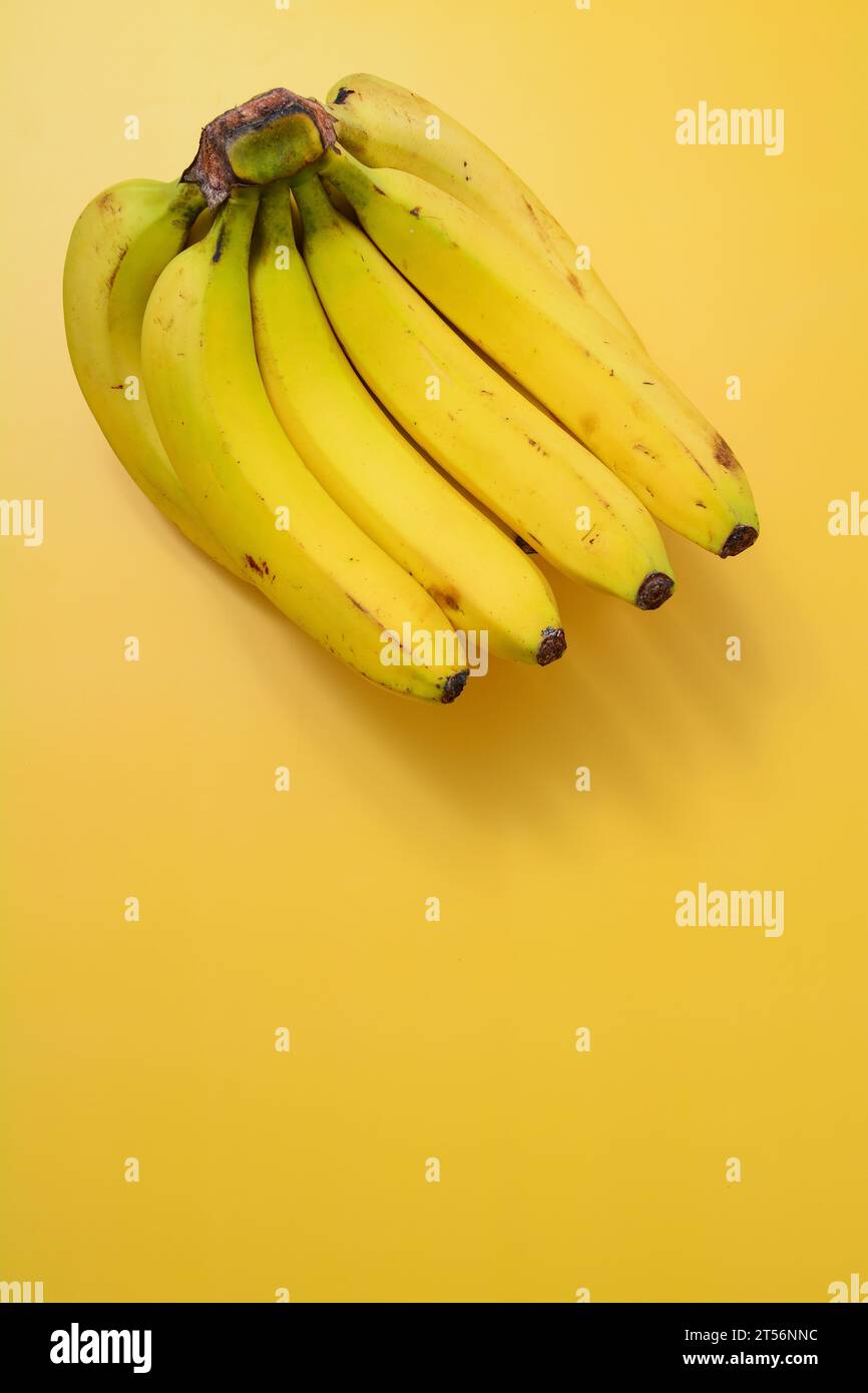 A bunch of bananas on yellow background Stock Photo - Alamy
