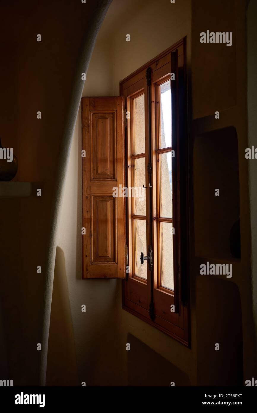 Light enters an attic room through a wooden window highlighting a ...