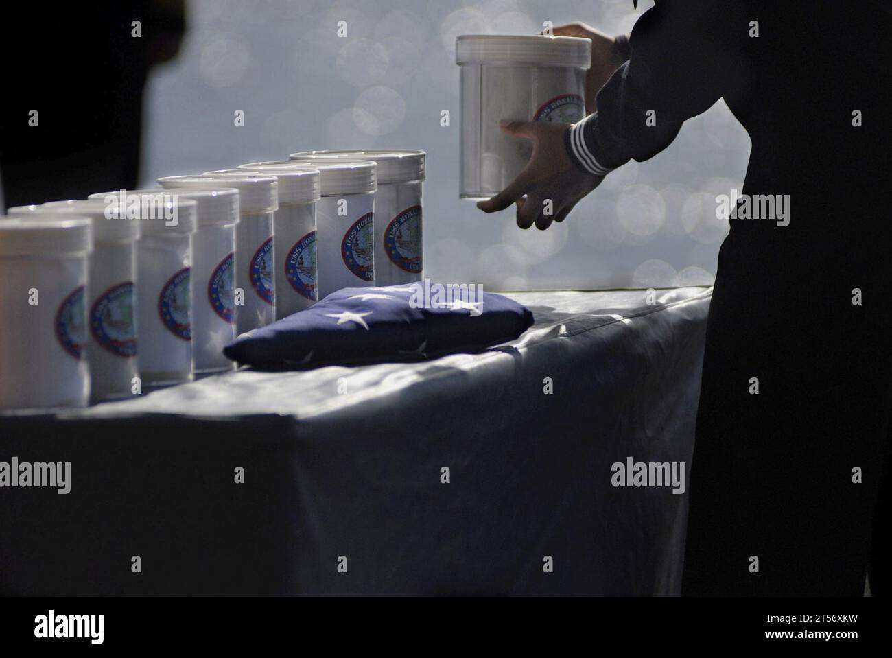 US Navy A burial-at-sea participant picks up the cremains of retired U ...