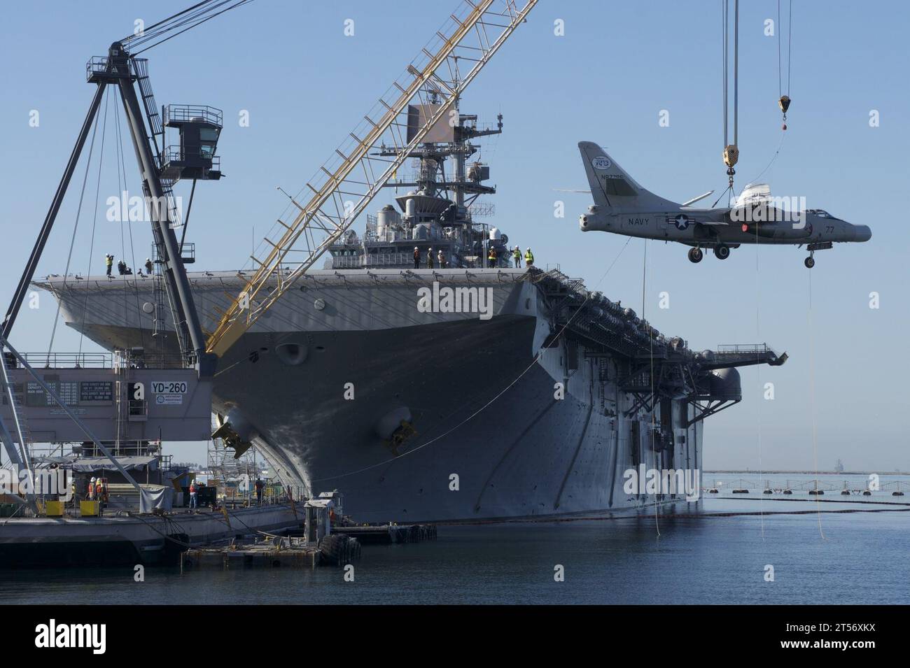 US Navy A barge crane lifts a Navy A3 to the flight deck of the ...
