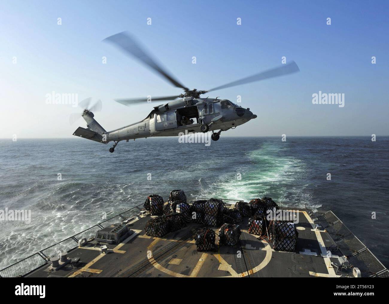 US Navy A helicopter turns away from the flight deck after lowering ...