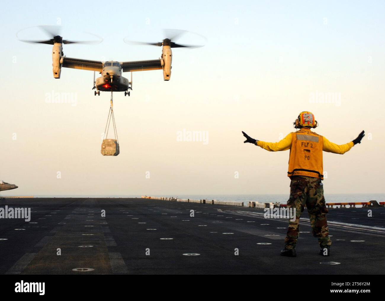 US Navy A landing signal enlisted directs an MV-22B Osprey assigned to ...