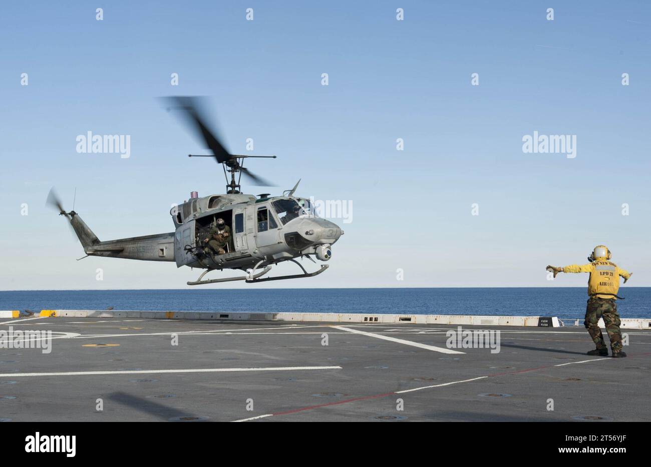 US Navy A Sailor directs a UH-1N Huey helicopter from Marine Medium ...