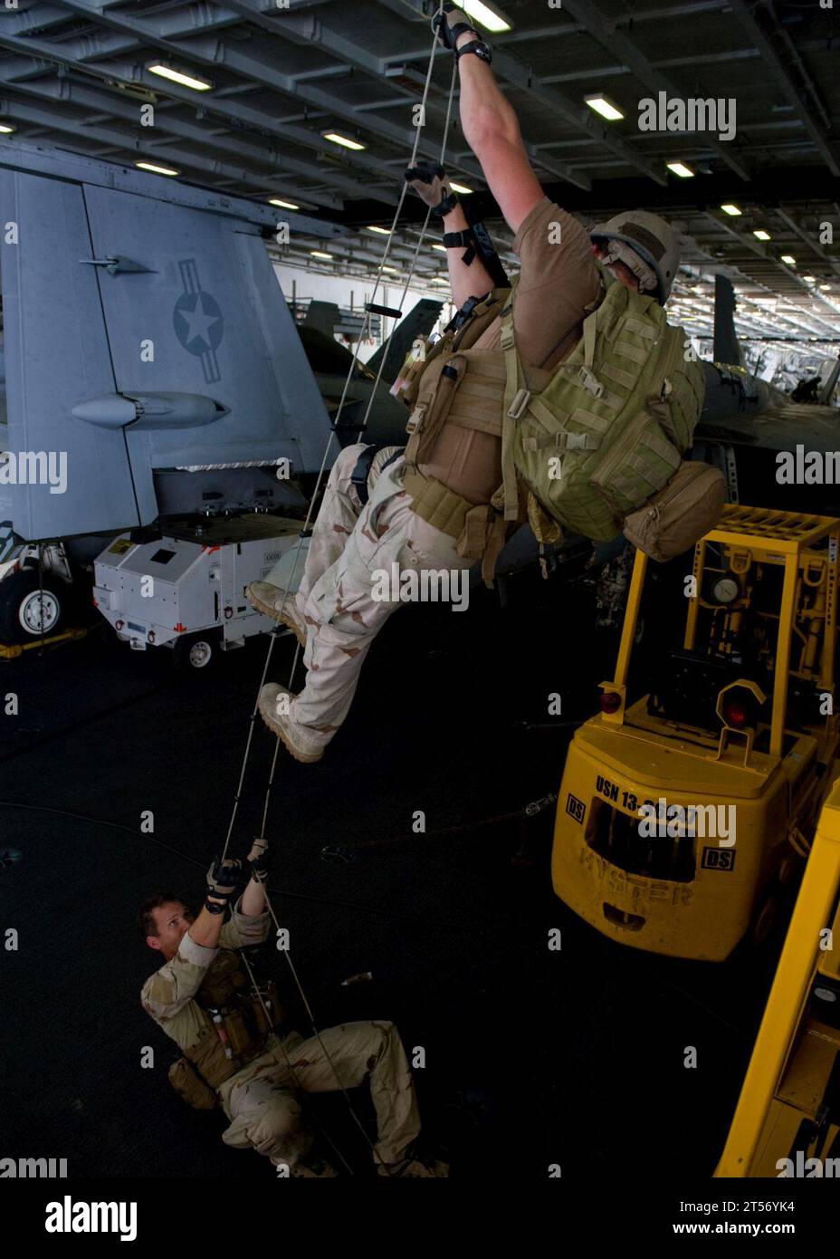 US Navy A Sailor climbs a collapsible rope ladder while another braces ...