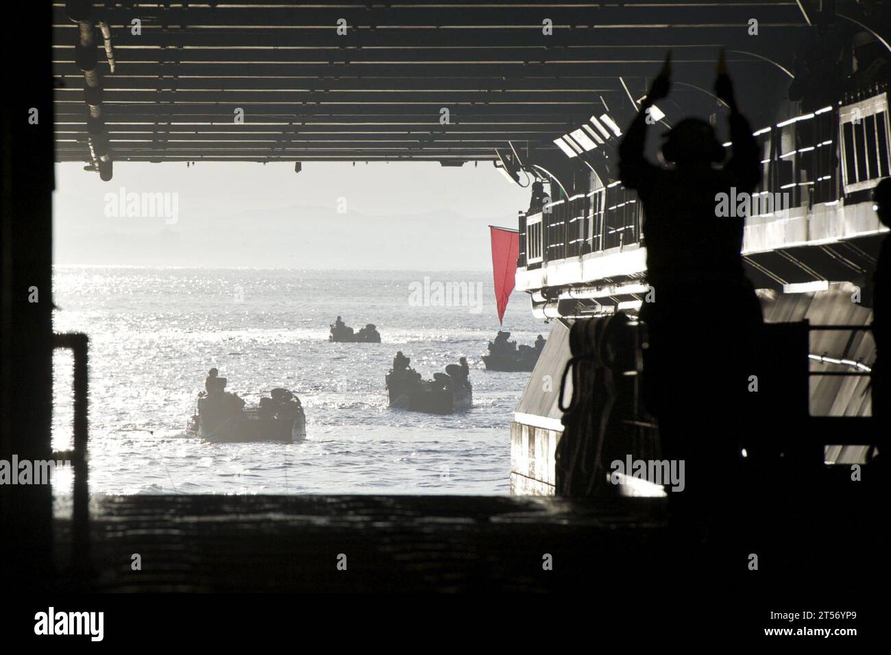 US Navy A Sailor guides amphibious assault vehicles into the well deck ...