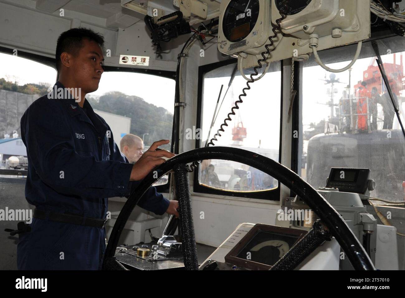 US Navy A Sailor pilots a tug that maneuvers the USS North Carolina.jpg ...
