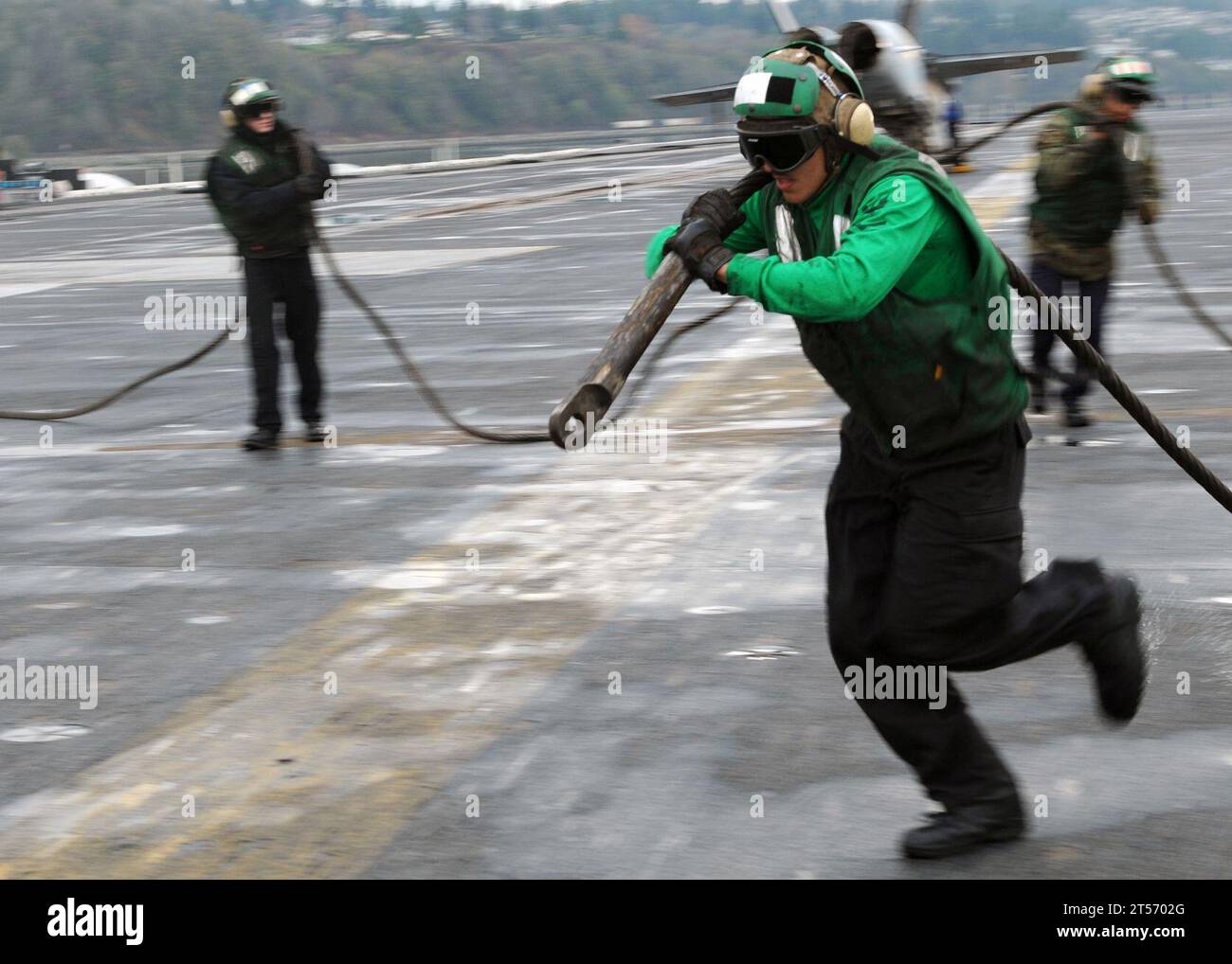 US Navy A Sailor runs line across the flight deck aboard the Nimitz ...
