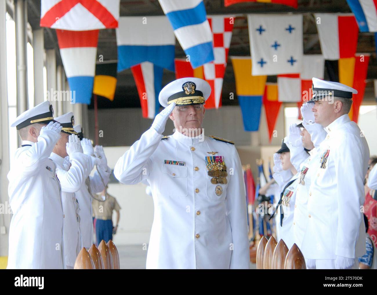 US Navy Adm. Robert. F. Willard renders a salute as he passes through ...