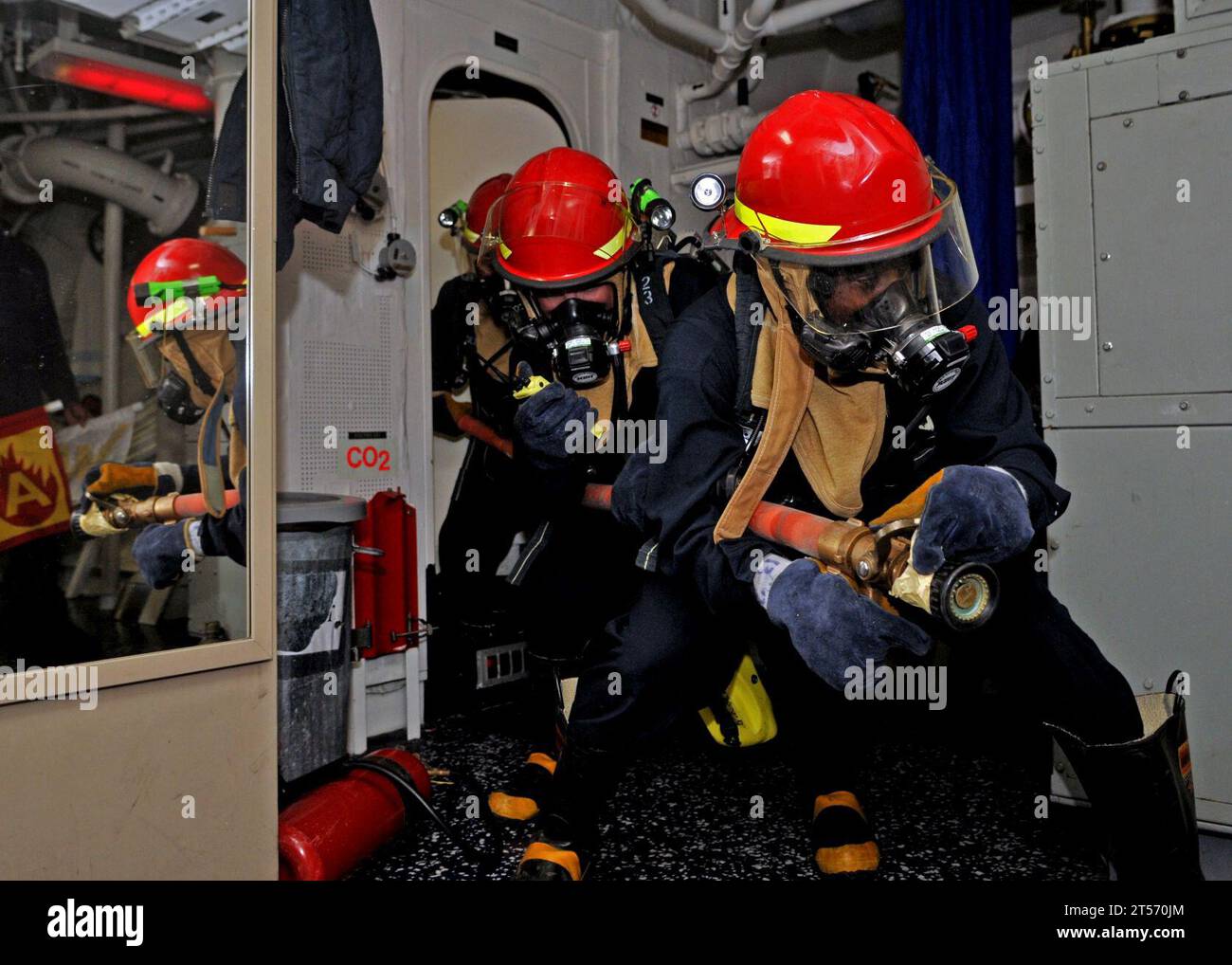 US Navy ailors simulate fighting a fire during a general quarters drill ...