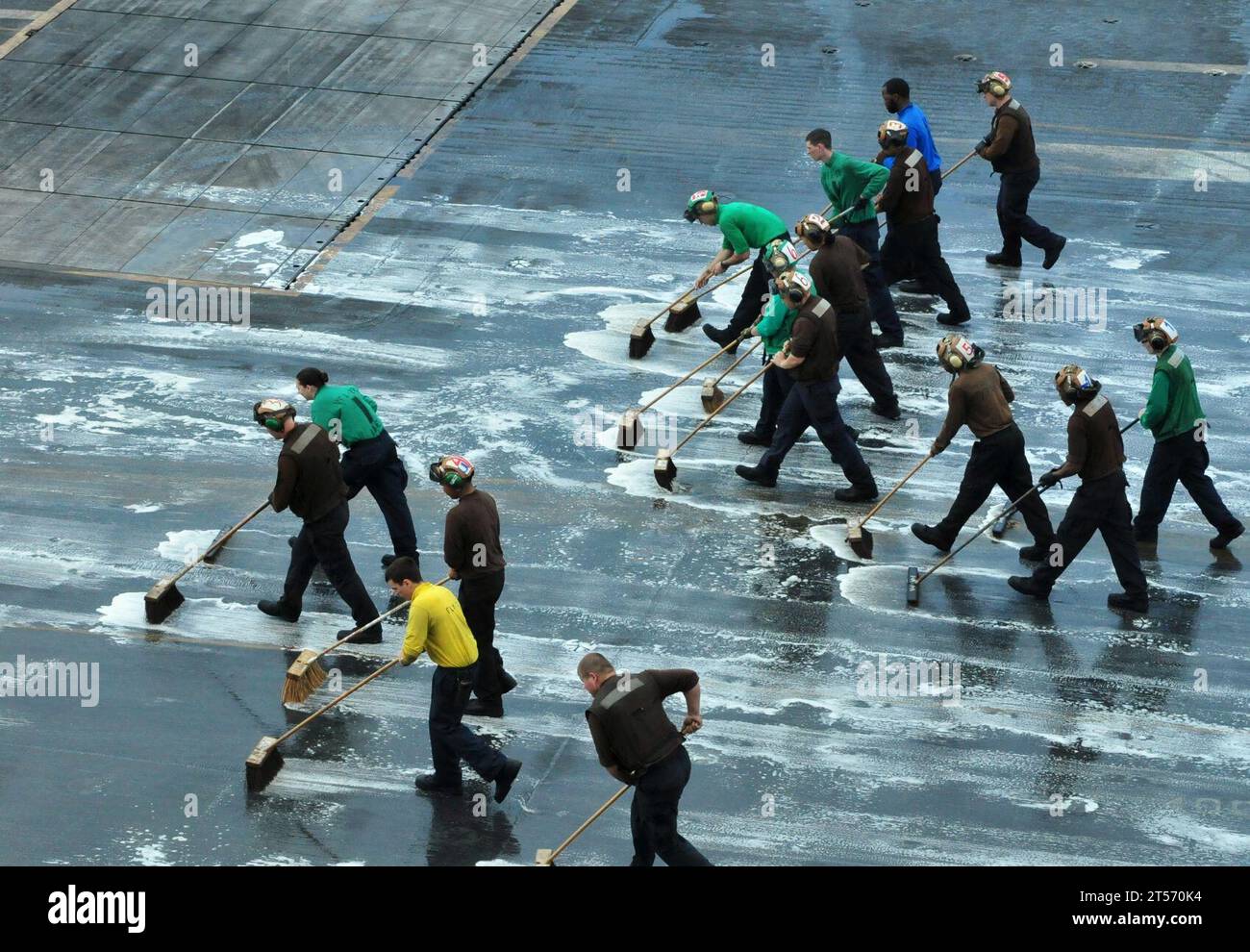 US Navy Air department and squadron personnel scrub the flight deck ...