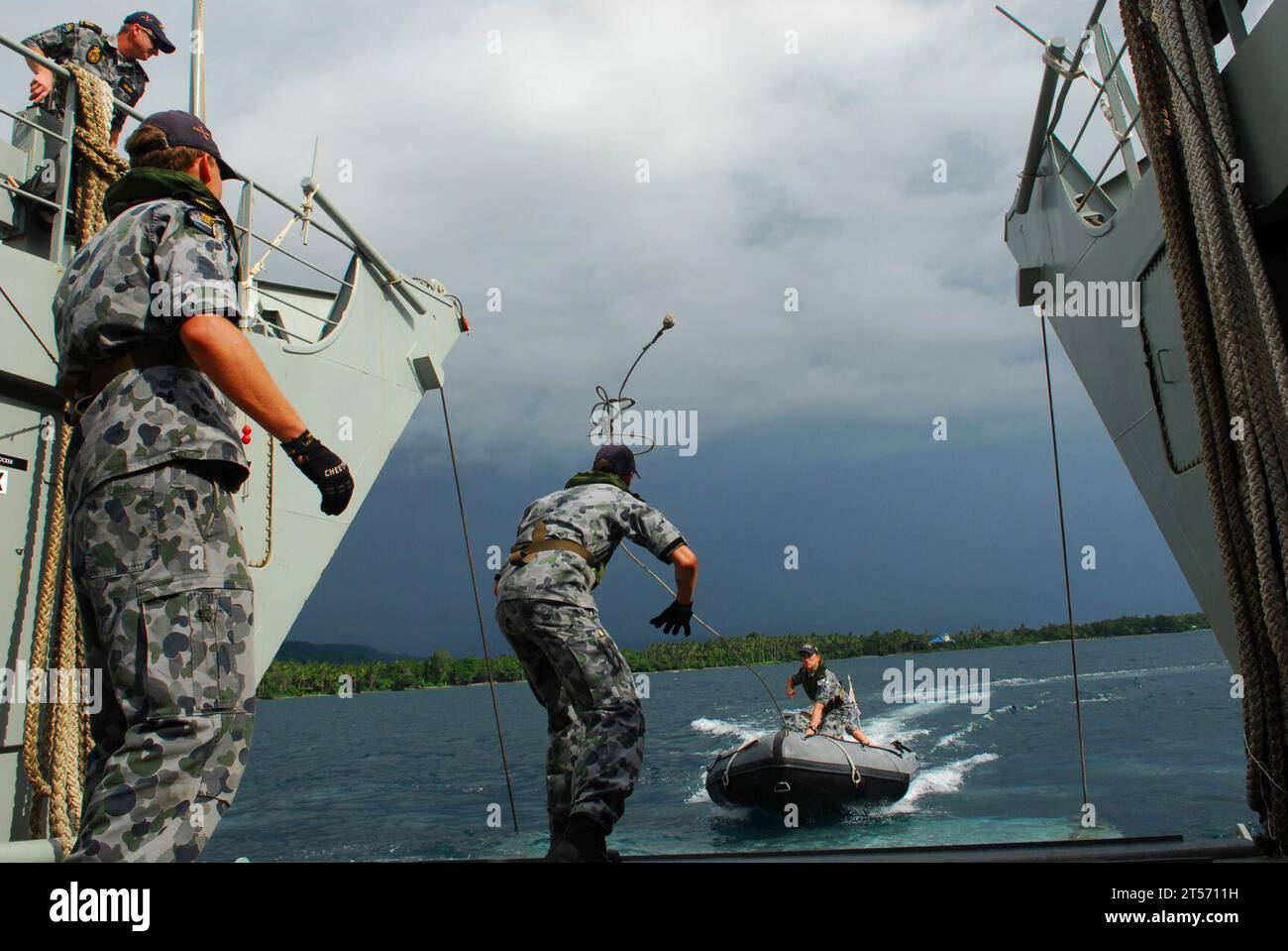 US Navy An Australian Royal Navy Sailor throws a line to Sailors aboard ...