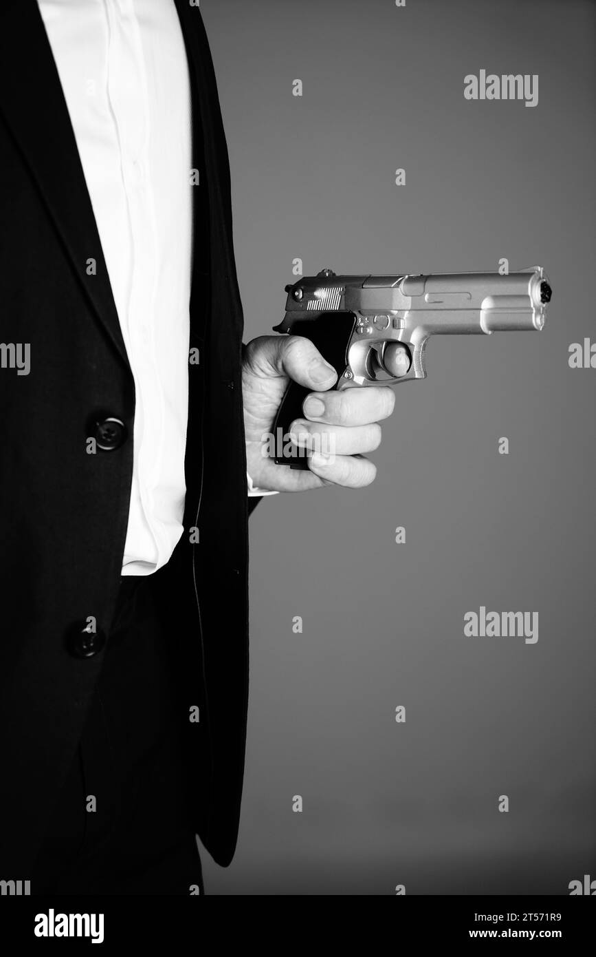 Retro secret agent with pistol revolver gun in hand in vintage crime ...