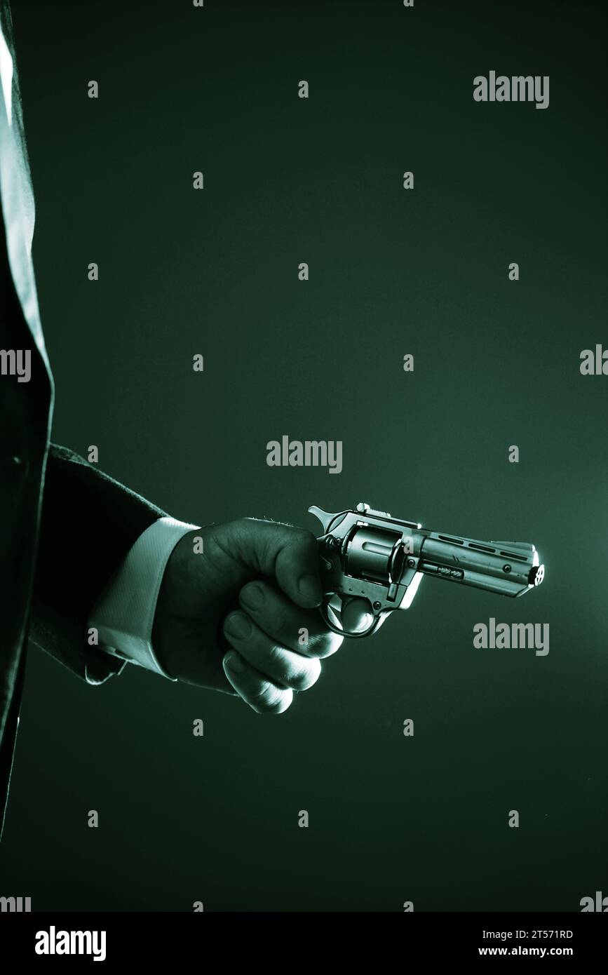 Retro secret agent with pistol revolver gun in hand in vintage crime ...