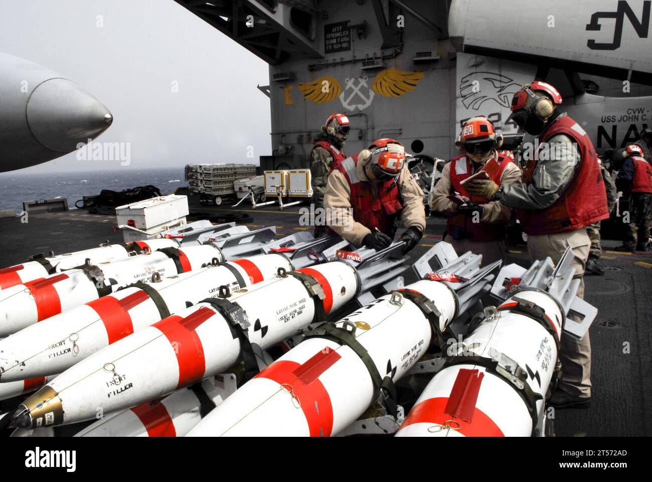 US Navy Aviation Ordnancemen inspect MK-62 mines on the flight deck of ...