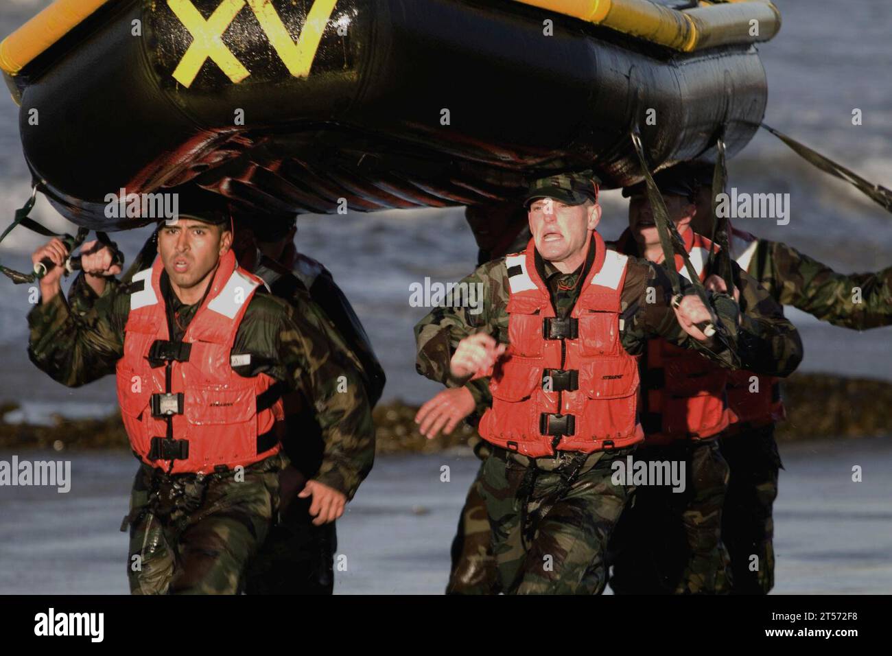 US Navy Basic Underwater Demolition(BUD)-SEAL students carry an ...