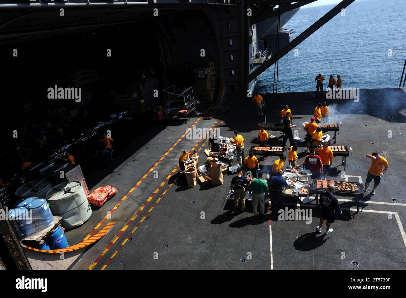 US Navy Chiefs cook on elevator four during a steel beach picnic aboard ...