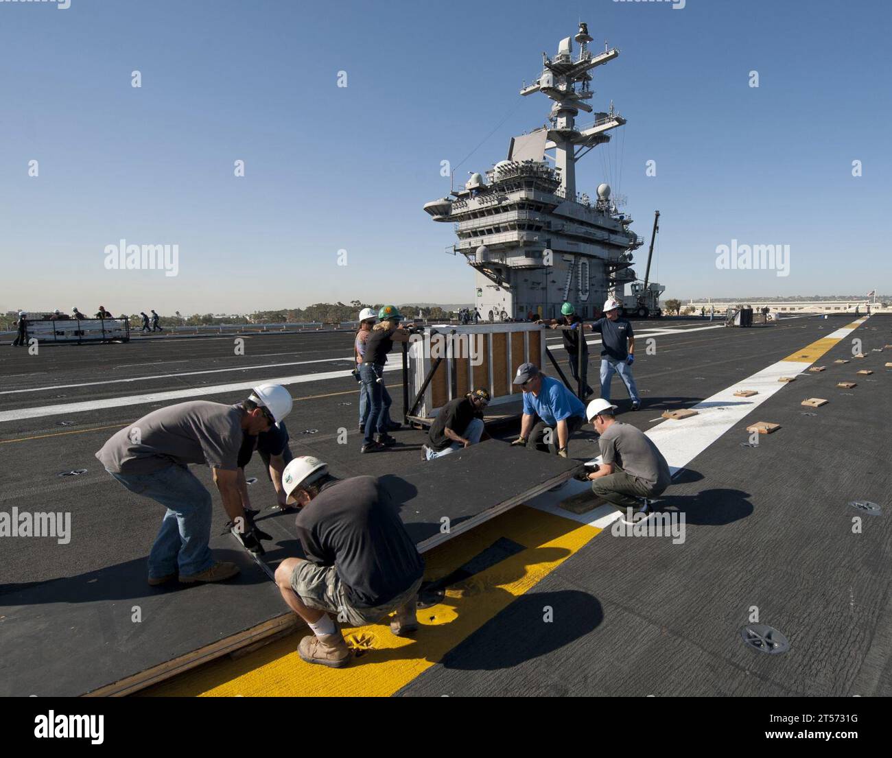 US Navy Civilian contractors lay down panels on the flight deck as ...