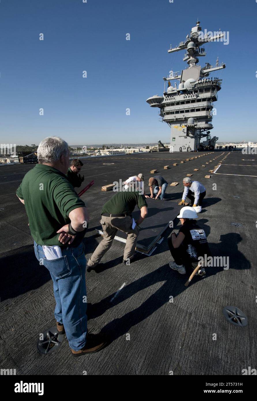 US Navy Civilian contractors lay down panels on the flight deck as ...