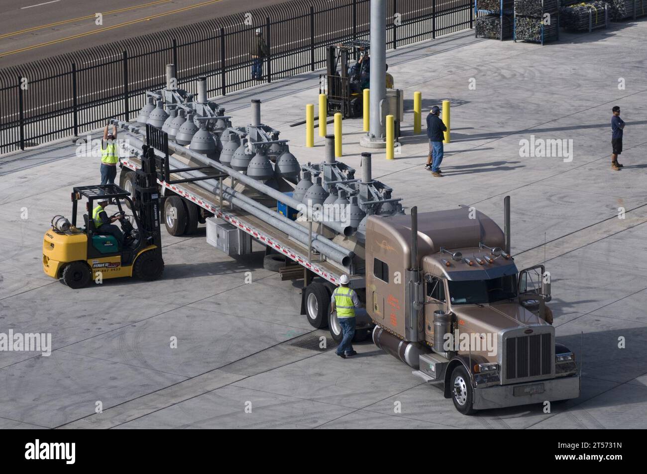 US Navy Civilian contractors offload lighting equipment on the pier as ...