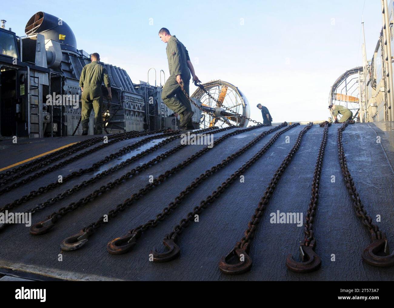 US Navy Crewmembers of a landing craft air cushioned clean the craft ...