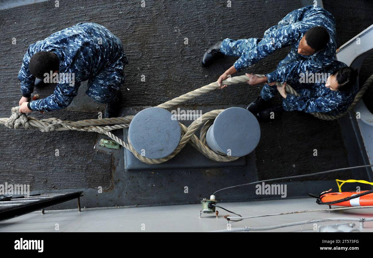 US Navy Deck department Sailors secure a line aboard the aircraft ...