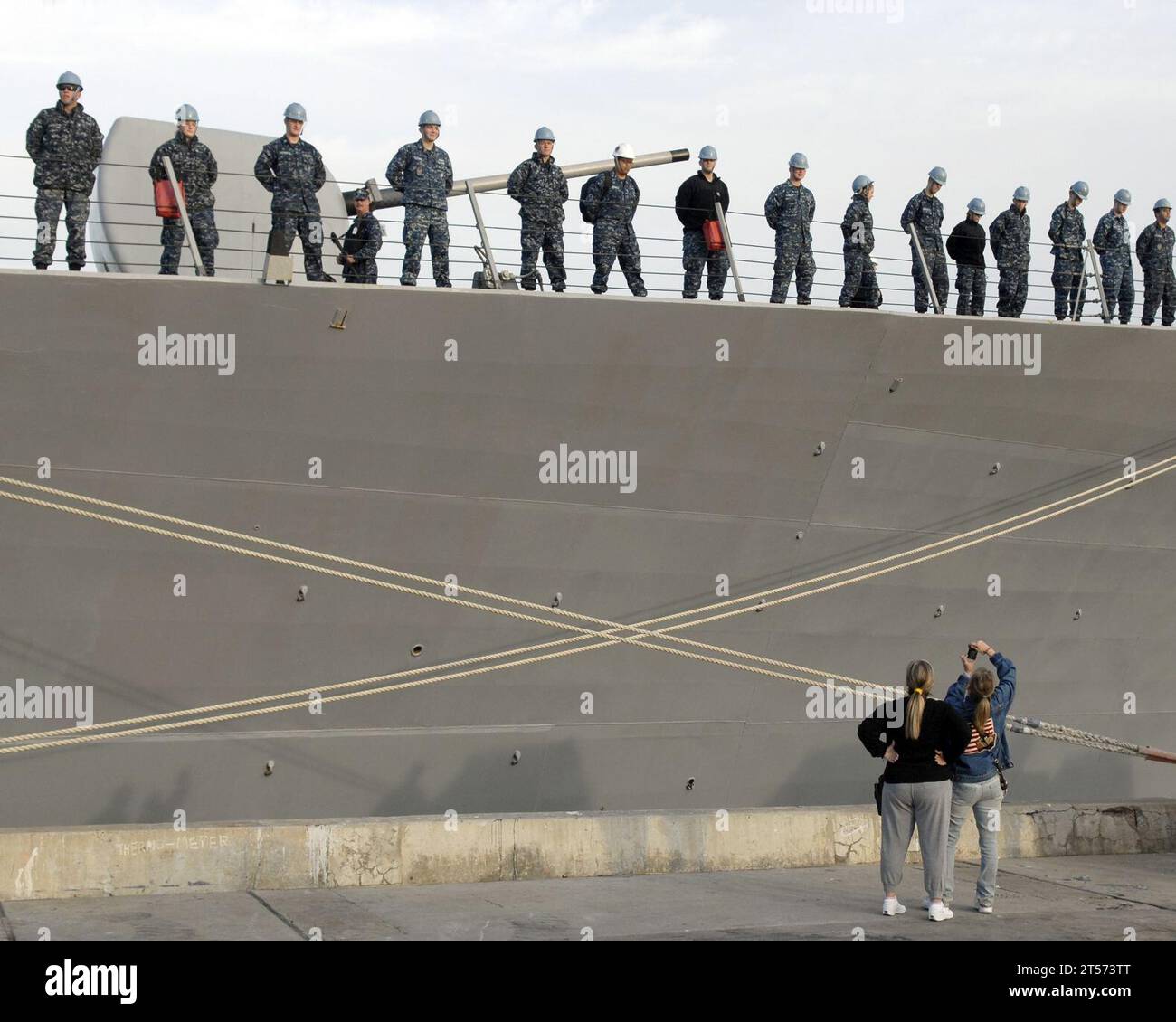 US Navy Family members take pictures of the crew of the guided-missile ...