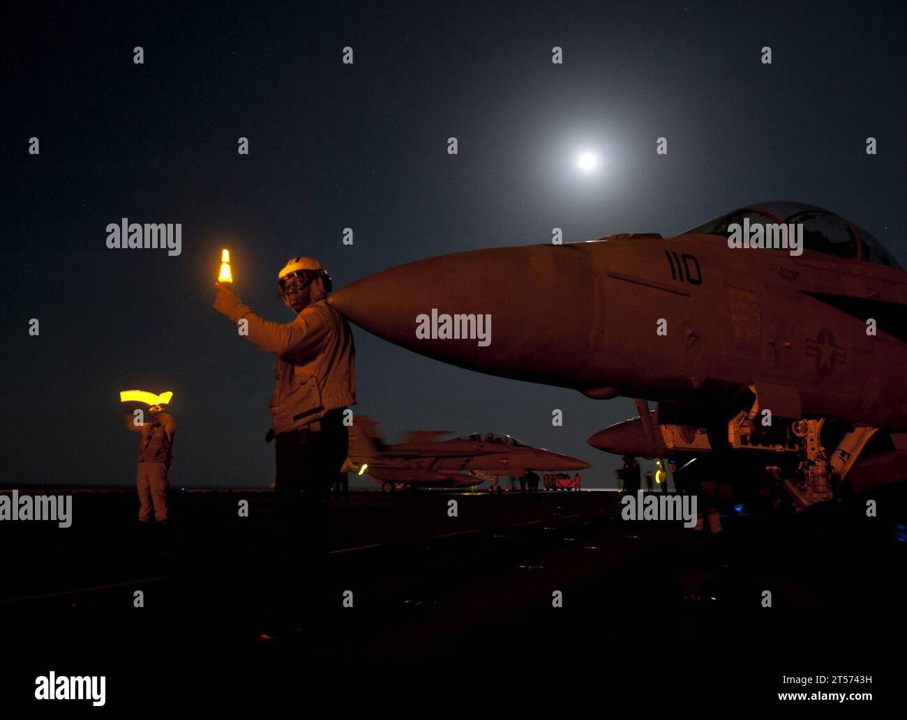 US Navy Flight deck personnel position aircraft after a recovery cycle ...