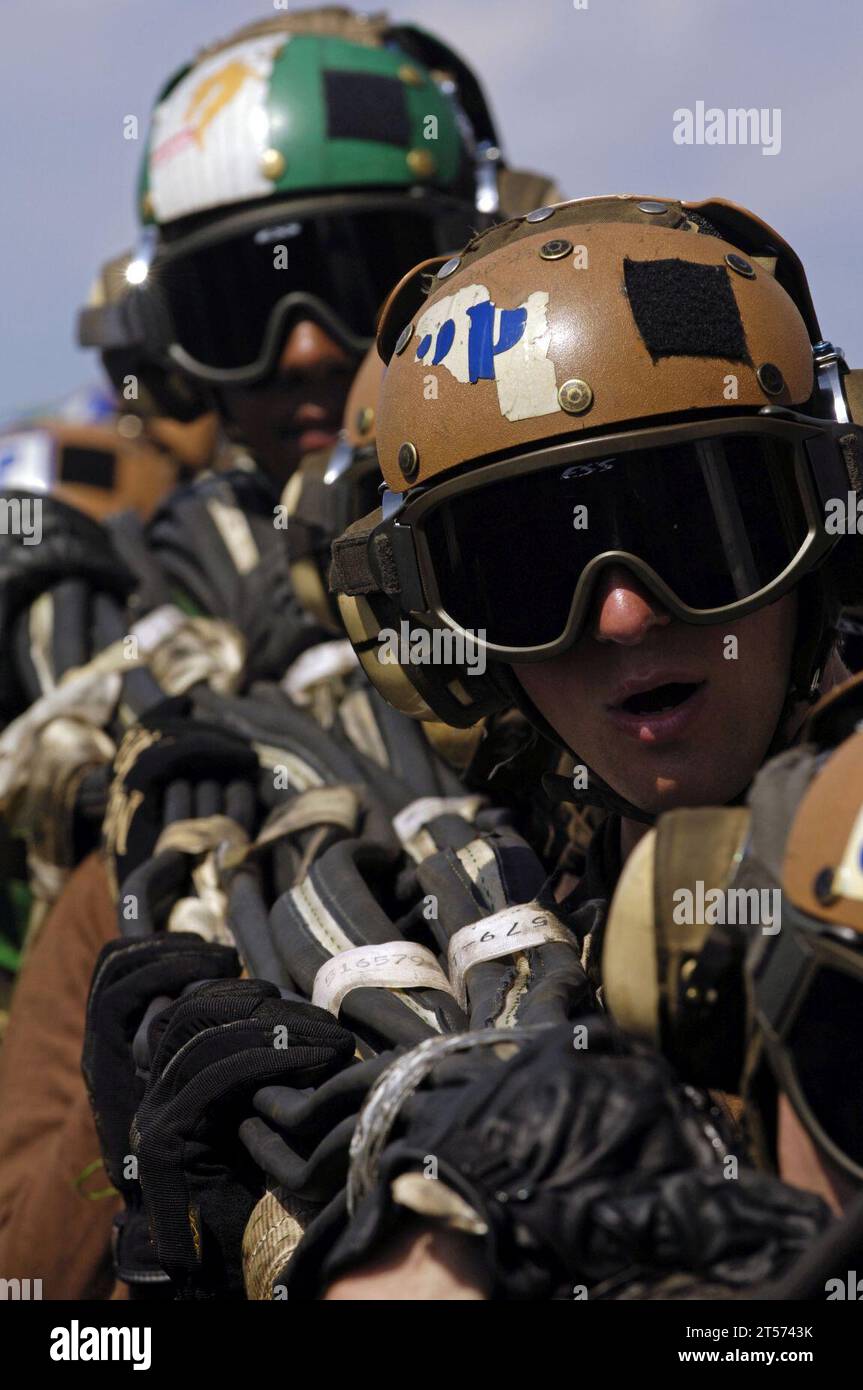 US Navy Flight deck personnel stow an aircraft barricade during damage ...