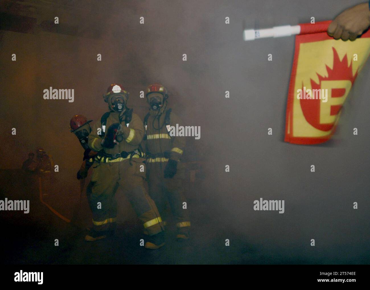 US Navy Hose team members simulate fighting a class bravo fire during a ...