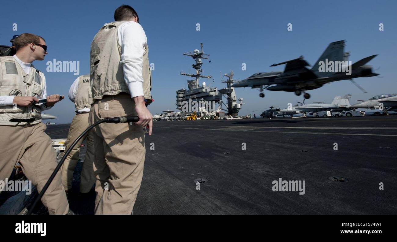 US Navy Landing signal officers observe as an F18C Hornet from the ...