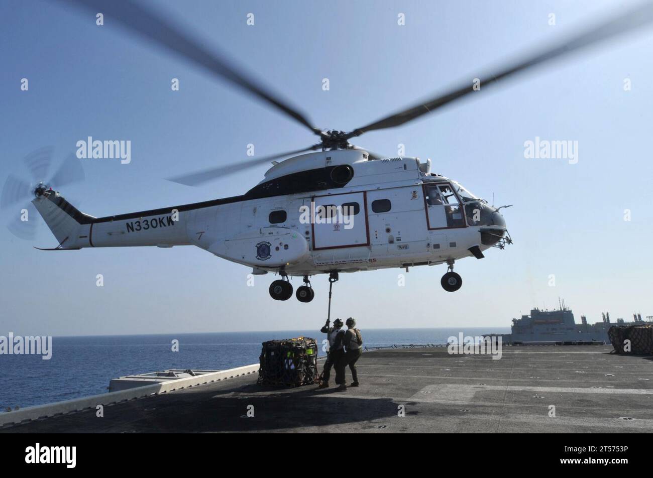 US Navy Marines assigned to Combat Cargo attach a hoist to an SA330J ...
