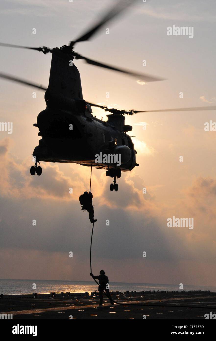 US Navy Marines drop from a CH-46 Sea Knight helicopter hile conducting a fast rope exercise ...