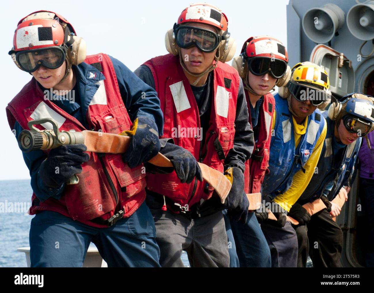 US Navy Members of the flight deck firefighting team conduct drills on ...