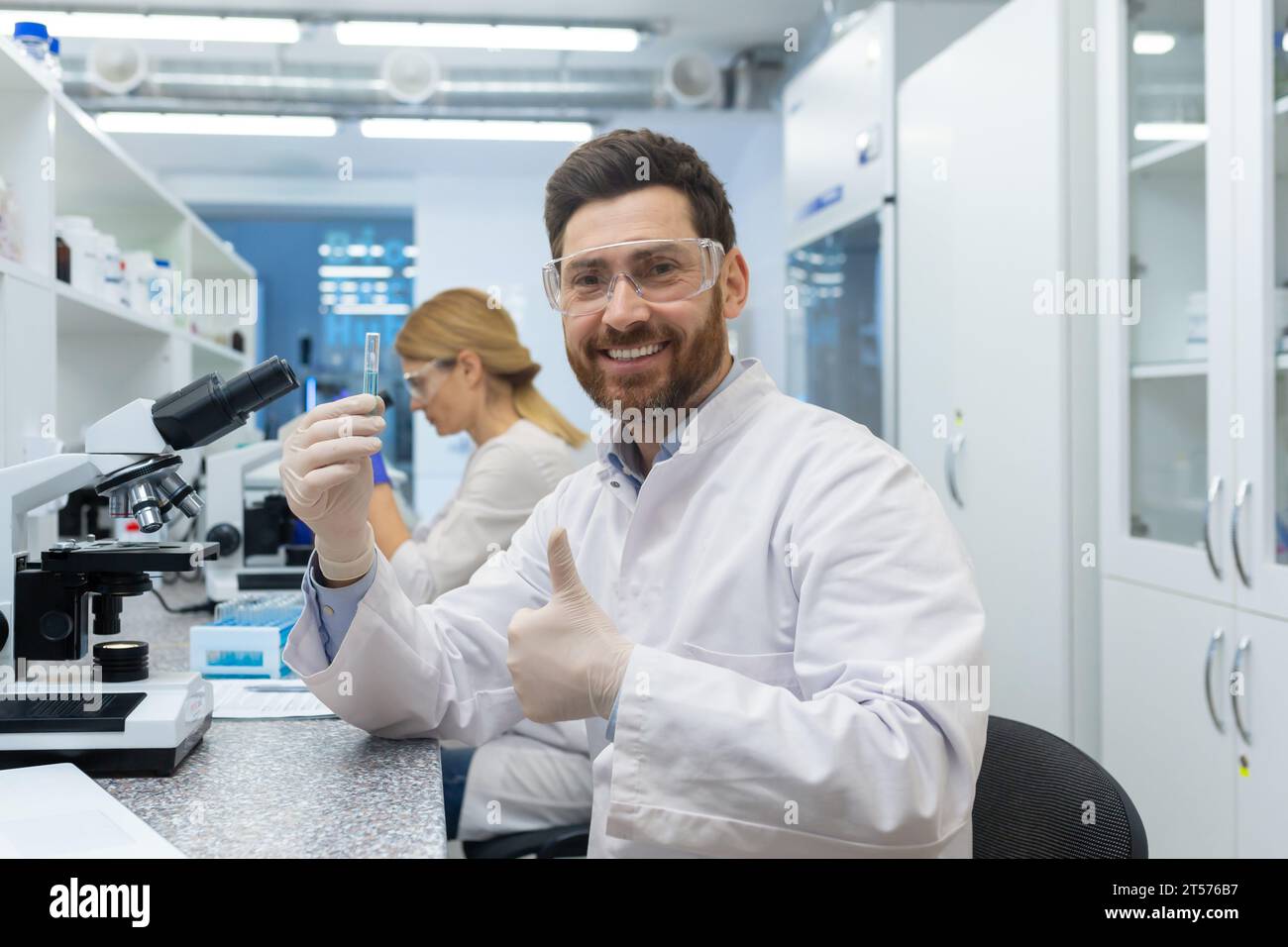 Satisfied with research results, scientist lab assistant shows thumbs ...
