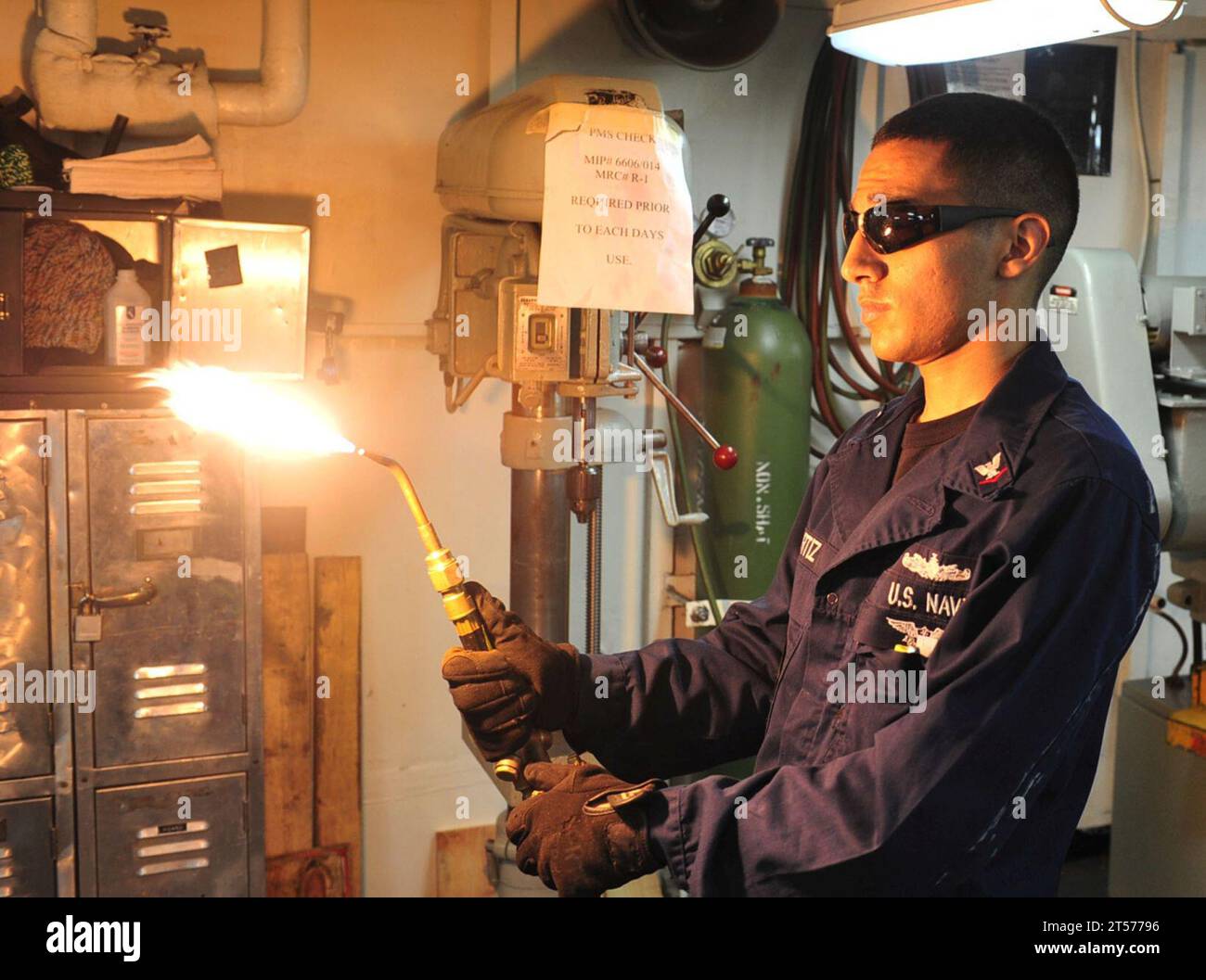 US Navy Sailor ignites an acetylene torch aboard aircraft carrier USS ...