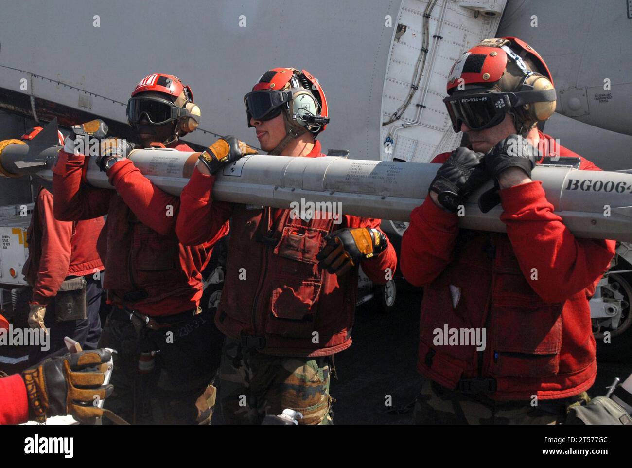 US Navy Sailors aboard the aircraft carrier USS Nimitz (CVN 68) move an ...